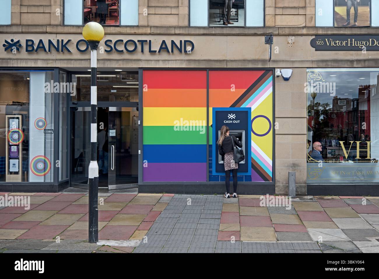 Customer using the ATM at a branch of the Bank of Scotland decorated in ...