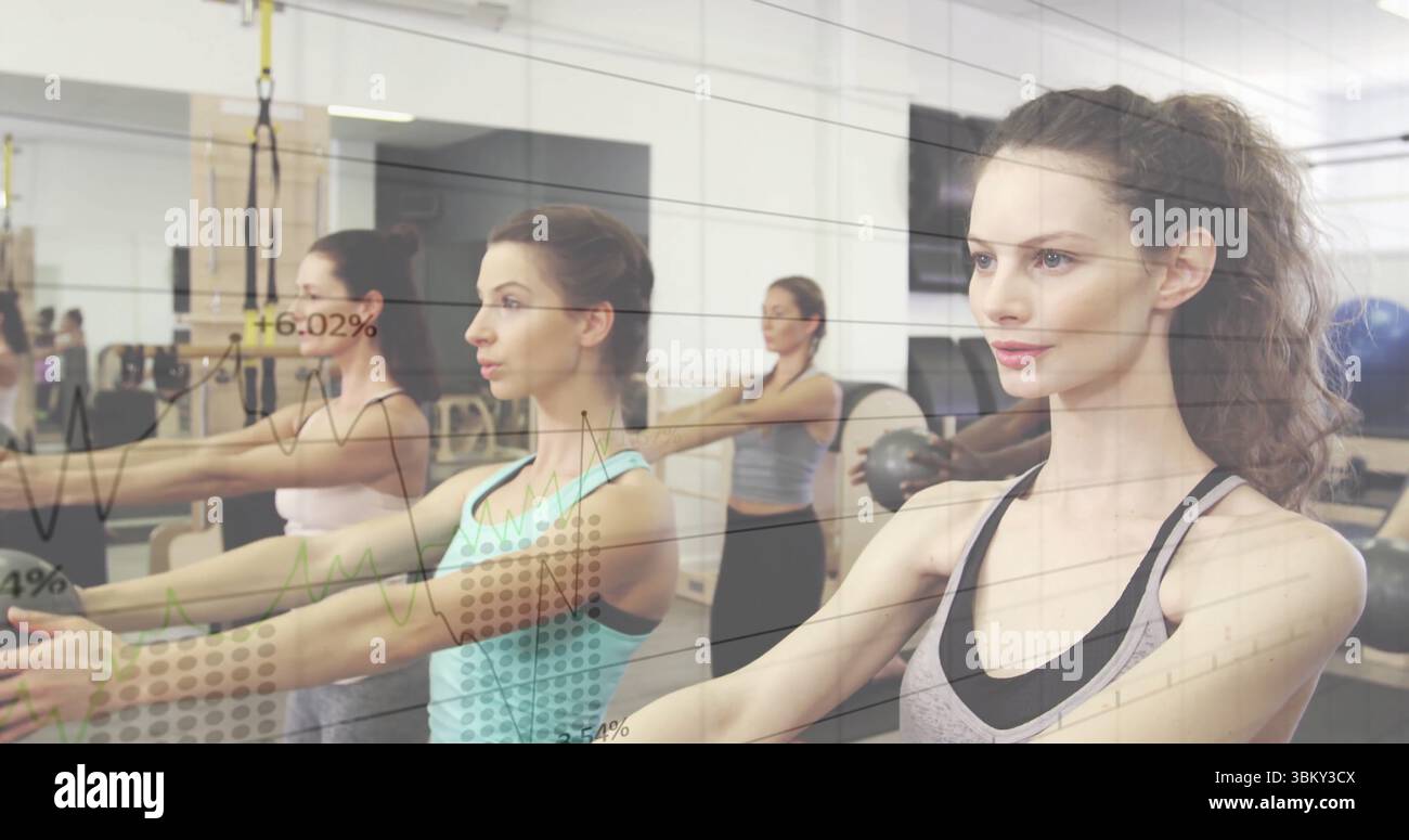 Extending arms forward, six women holding posture in studio, with ...