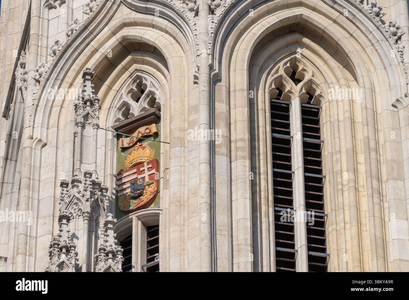 Gothic church facade with Hungarian historical coat of arms and arched ...