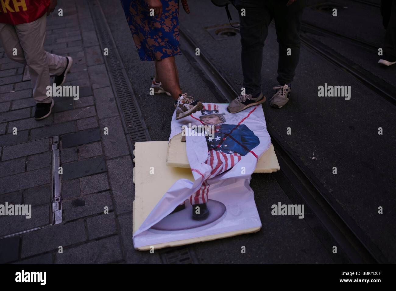People step on a broken placard with the image of Uncle Sam during a ...