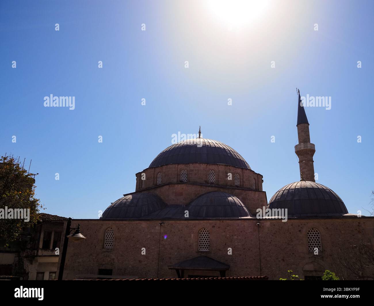 A low-angle shot captures the grandeur of a mosque under a clear blue ...