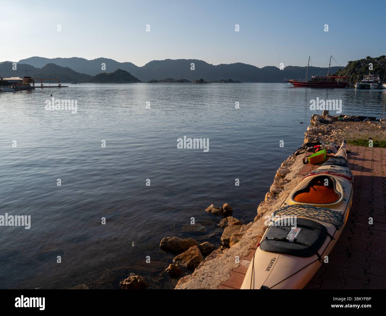A kayak rests on a brick and stone dock, ready for someone to take it ...