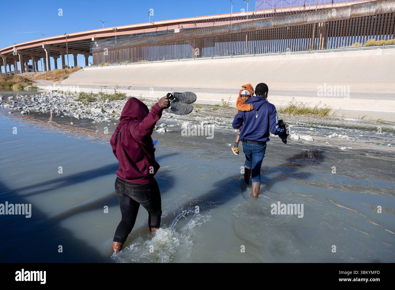 Several people wade through a shallow river Stock Photo - Alamy