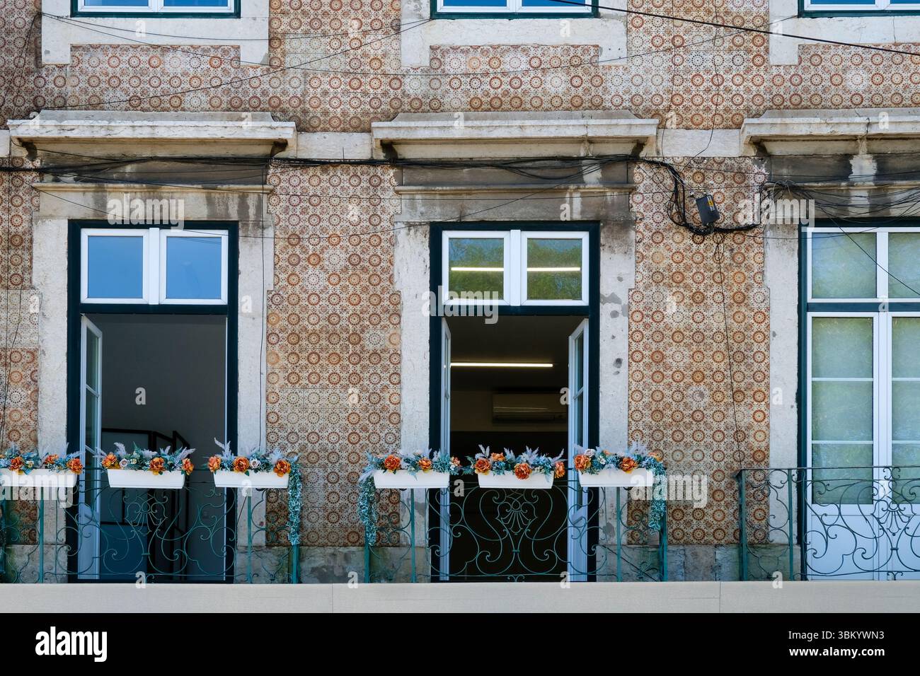 Flowers on balcony railings and tiles adorn buildings in Lisbon ...
