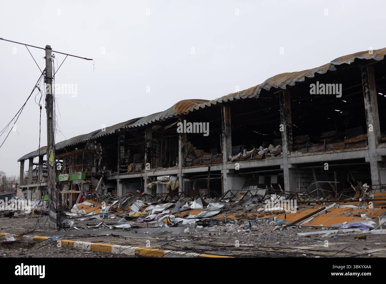 A large commercial building shows signs of extensive damage, with a ...