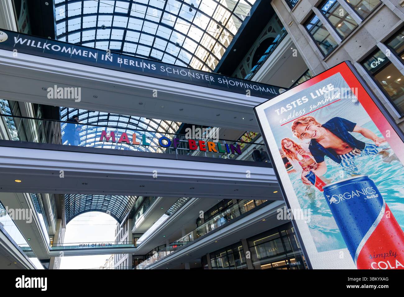 Mall of Berlin interior view with glass ceiling, colorful logo and large LED billboard showing ...