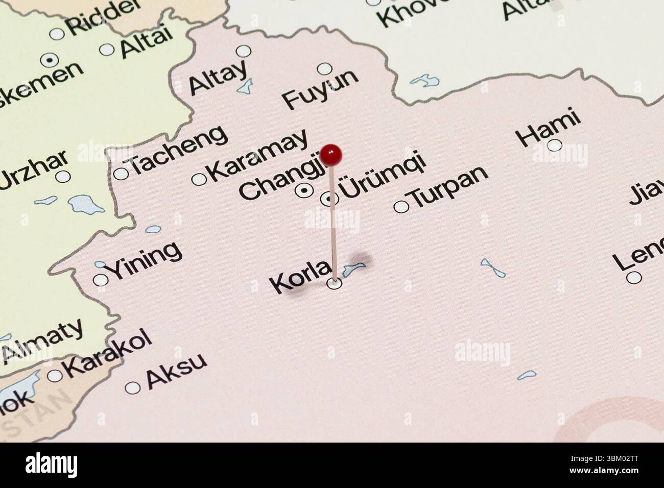 macro photo of a red pin needle into Korla city of China political map ...