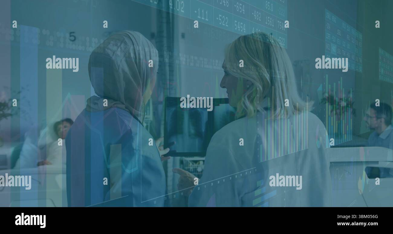 Medical professionals wearing lab coats reviewing tablet scan in ...