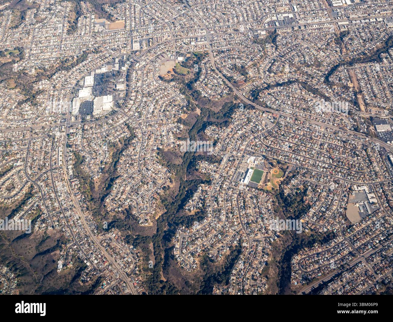 An aerial view shows a densely populated suburban area with winding ...