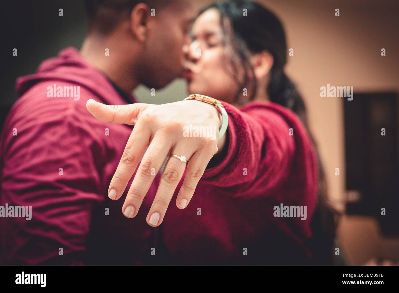 Newly engaged couple kissing while showing off the ring Stock Photo - Alamy