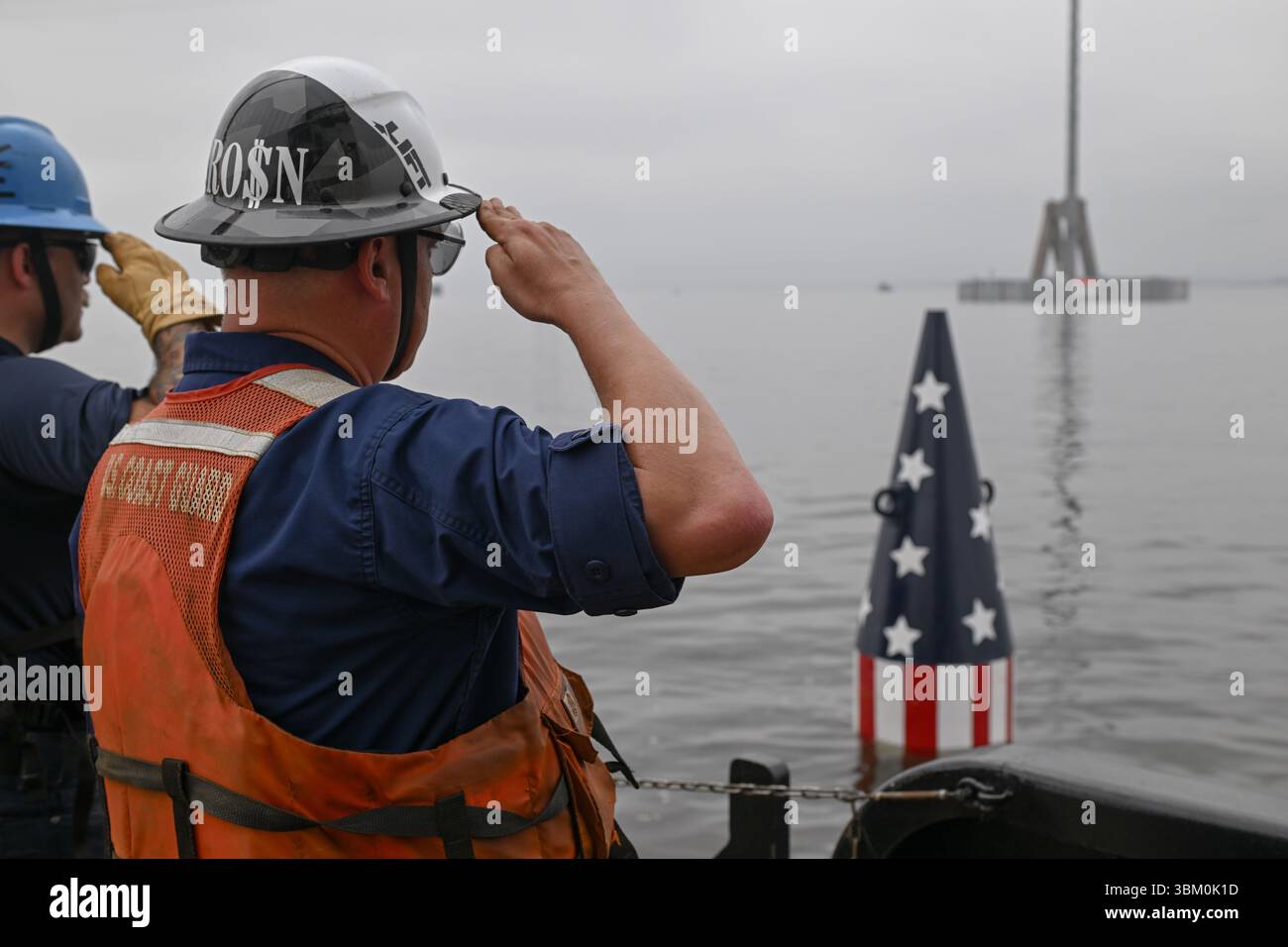 A crew member aboard U.S. Coast Guard Cutter William Tate salutes the ...