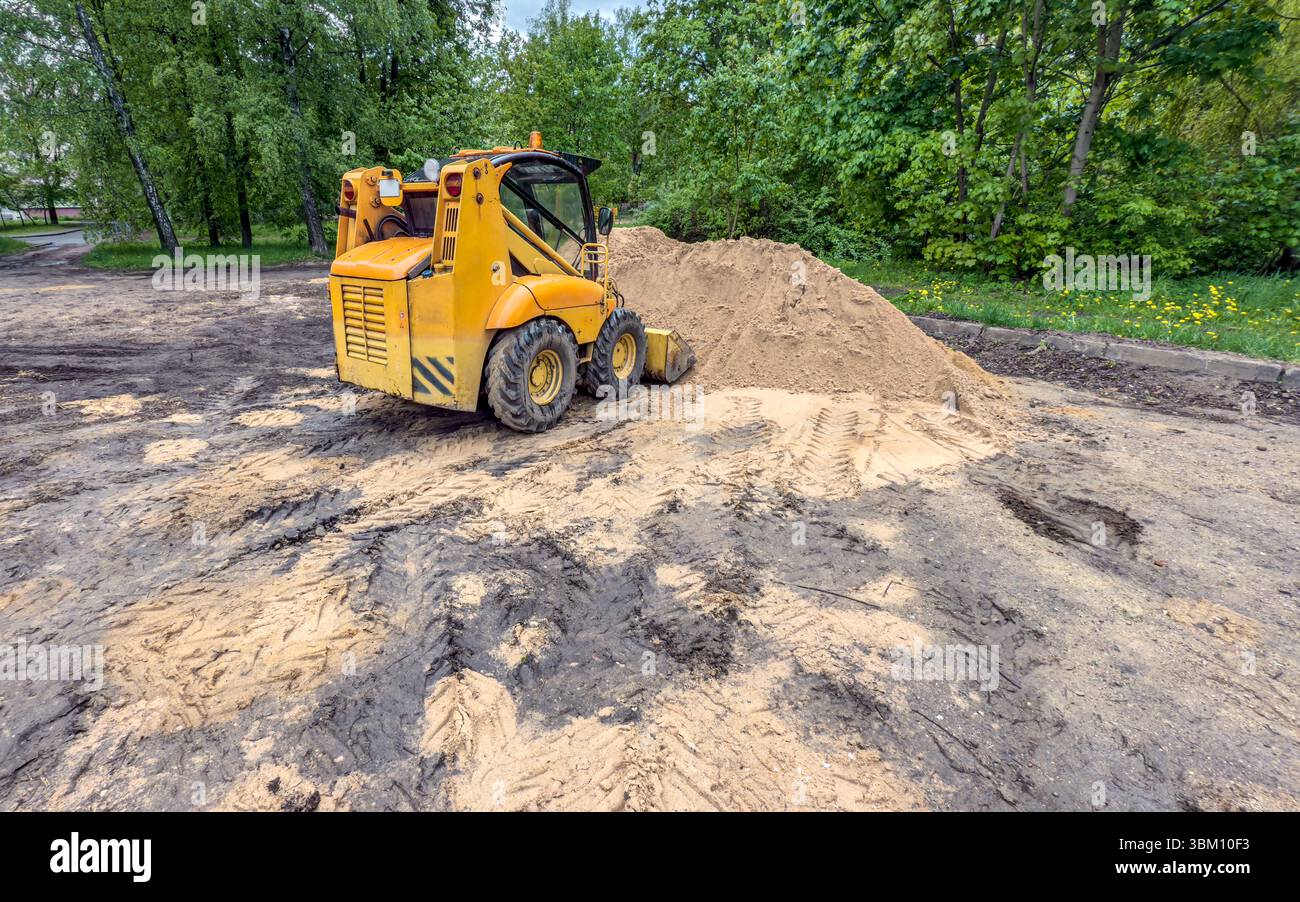 earthmoving machine is leveling the construction site. mini-loader ...