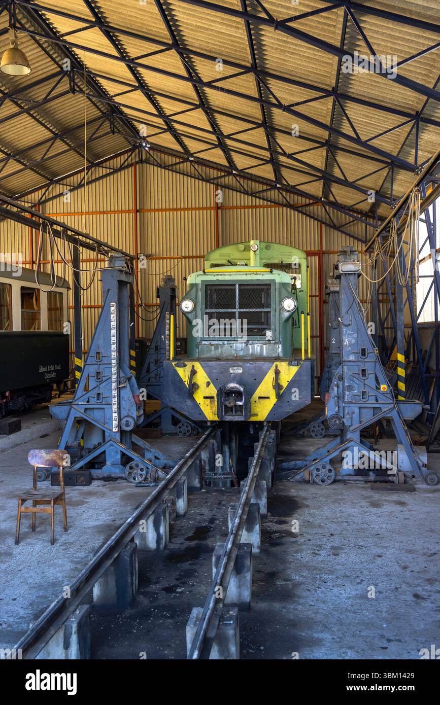 Old train engine undergoing maintenance inside a train depot in ...