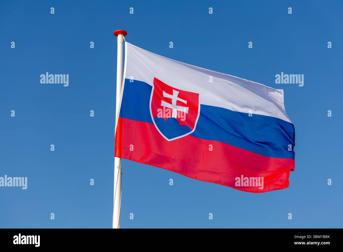 Slovak flag waving in the wind against a clear blue sky. Features the ...