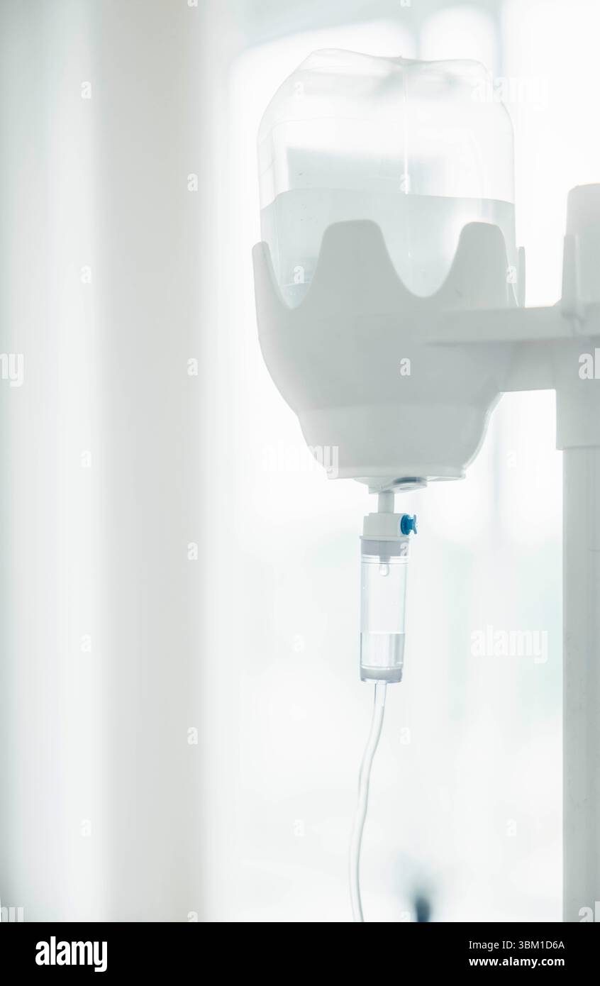 closeup of medical intravenous fluid drip chamber, hospital environment ...