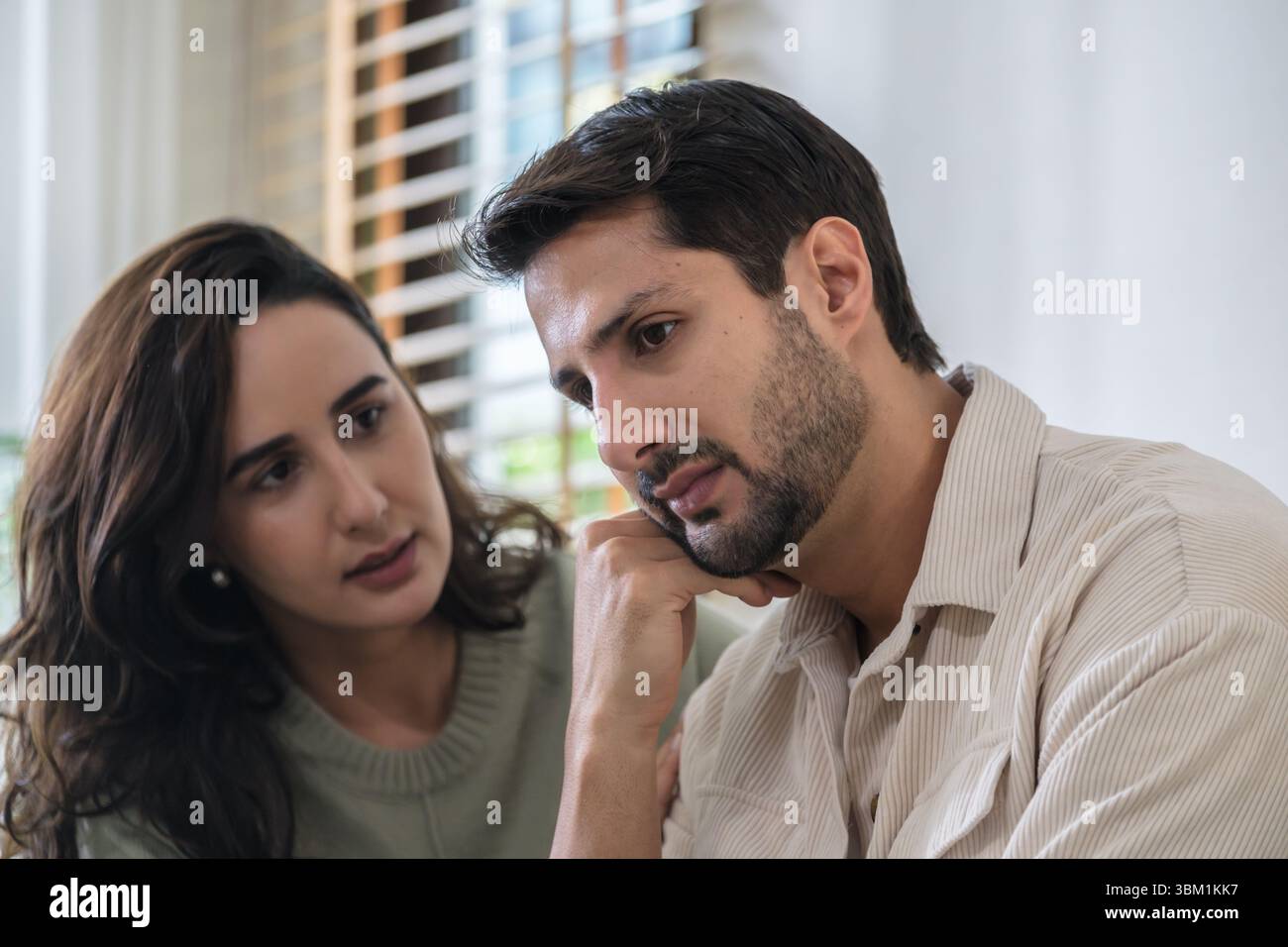 Supportive couple in emotional moment at home as woman struggles with ...