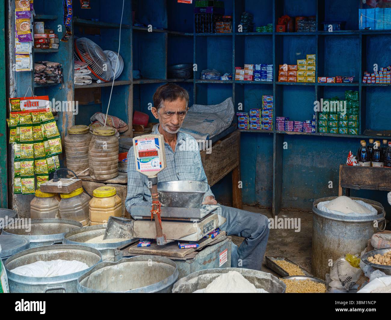 India, New Delhi, 25 Jun 2025. Local shopkeeper weighing sweets at a ...