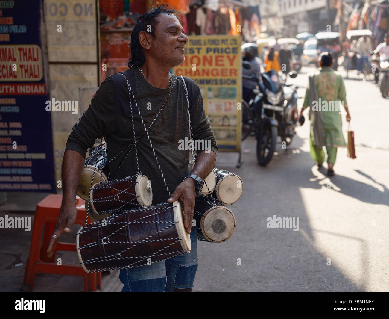 India, Delhi, 25 Jun 2025. Street musician carrying traditional Indian ...