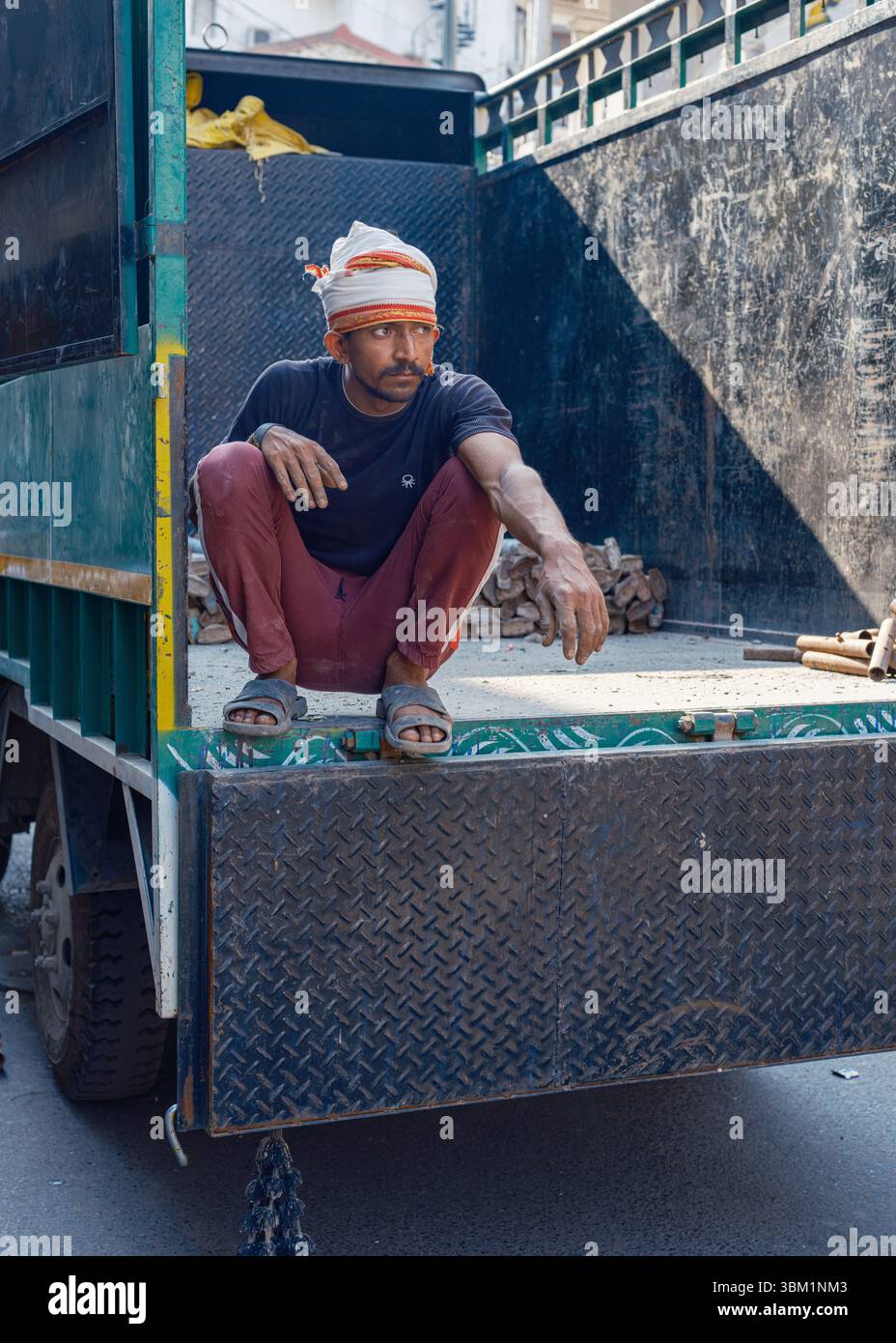 India, New Delhi, 25 Jun 2025. Local worker resting on the back of a ...