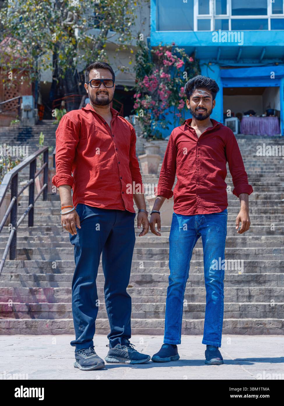 India, Varanasi, 16 Mar 2025. Two young men in matching red shirts and ...