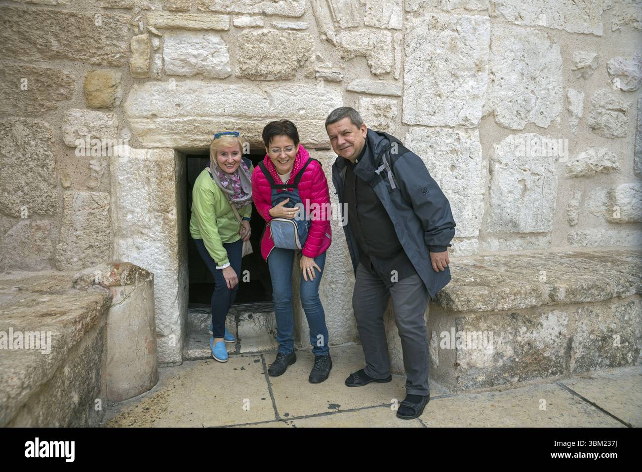 Bethlehem, tourists passing through small entrance to the Basilica of ...