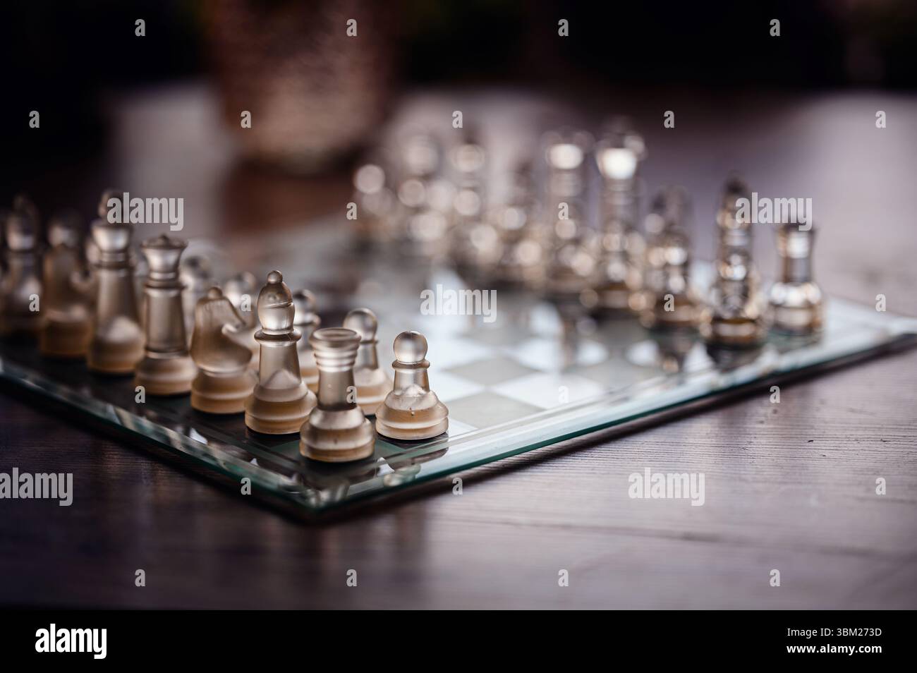Frosted glass chess pieces set up for play on a clear glass board ...