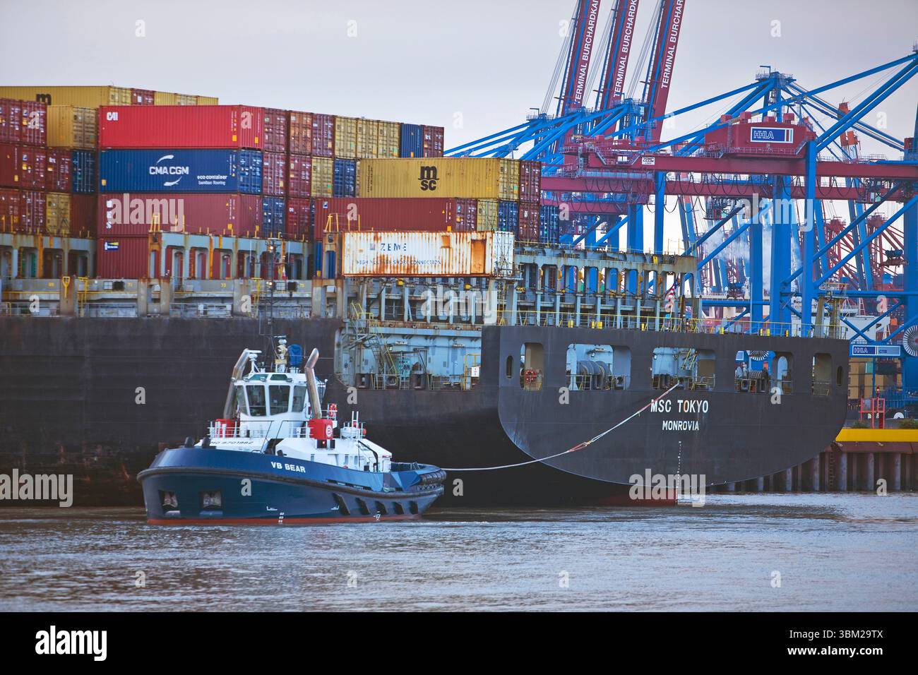 tugboat with large container ship at the Burchardkai container terminal ...