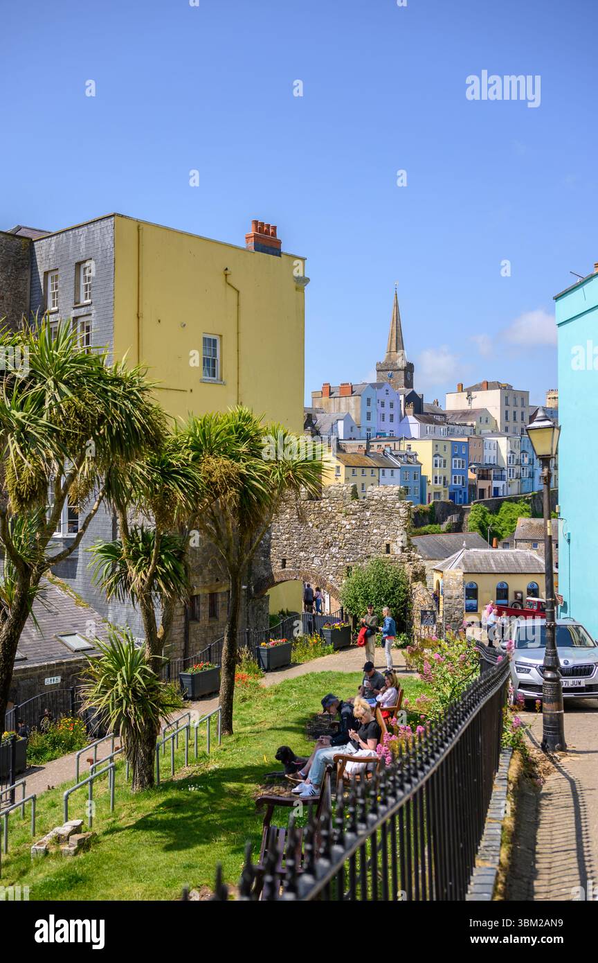 People in gardens near castle beach Tenby with the town in the ...