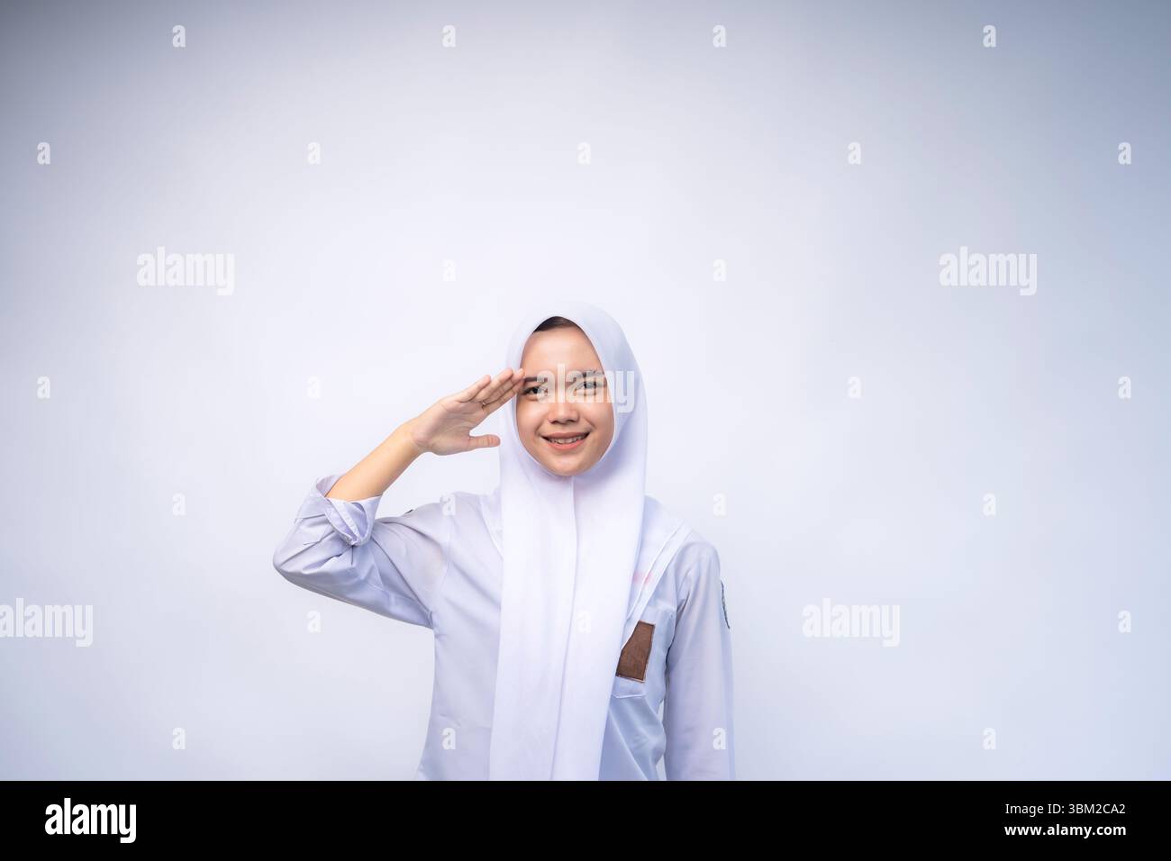 Female Indonesian high school student in white and grey uniform doing ...