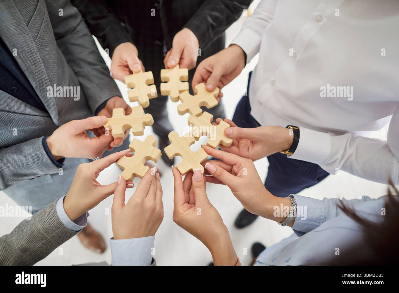 Business team connecting wooden puzzle pieces in circle, showing unity ...