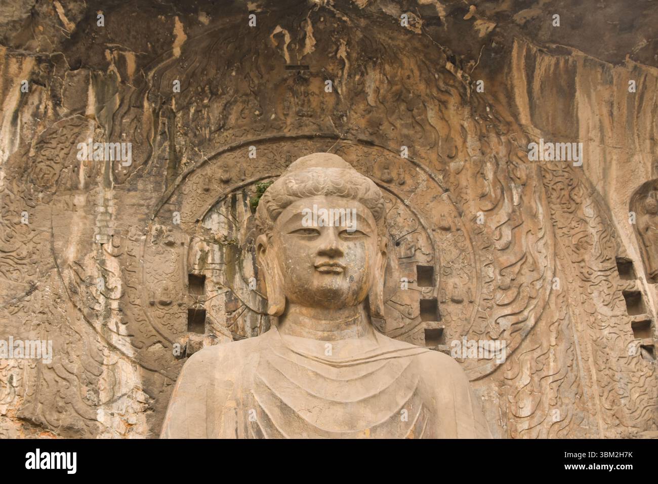 A large statue of the Buddha at Longmen Grottoes in Luoyang, China ...