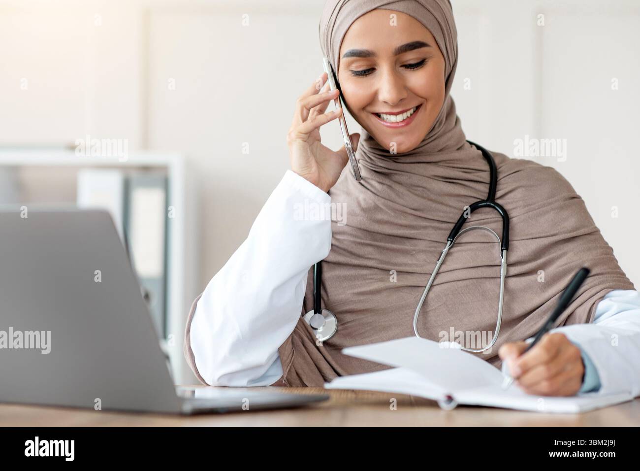 Happy muslim woman doctor having conversation on phone with patient ...