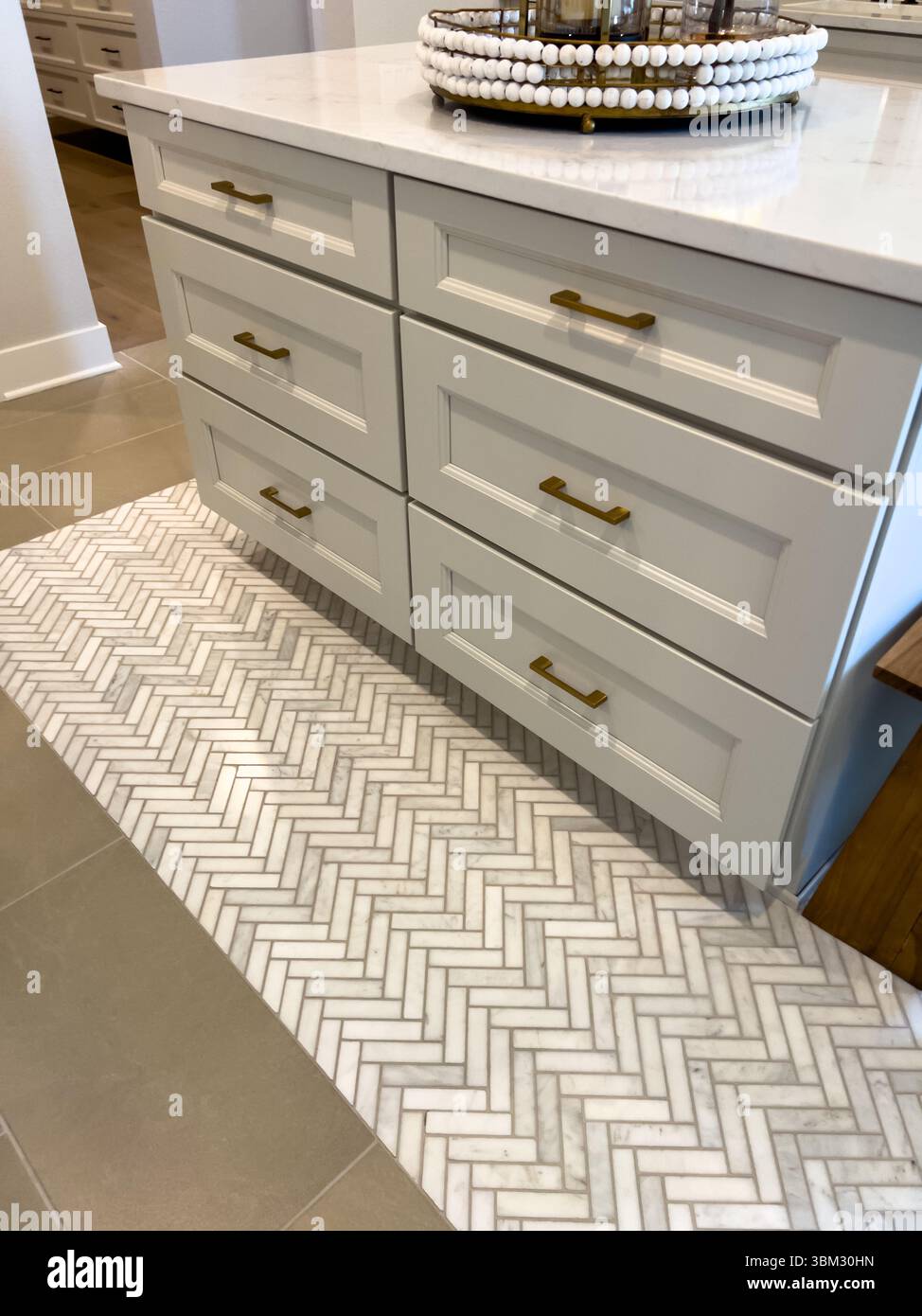 White Kitchen Island with Brass Handles and Herringbone Floor Tile ...