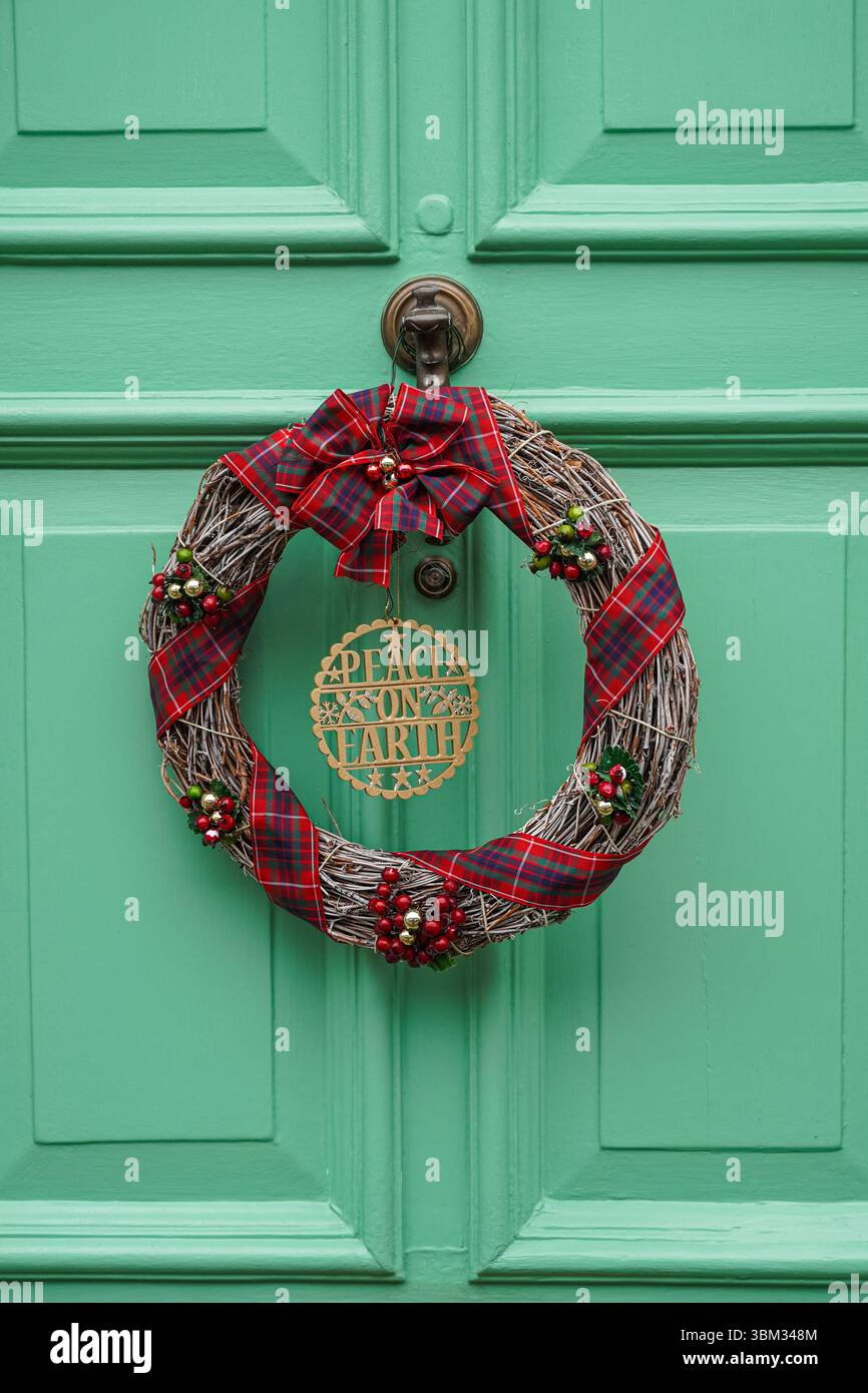 Decorative Christmas wreath hangs on a front door of a house in ...