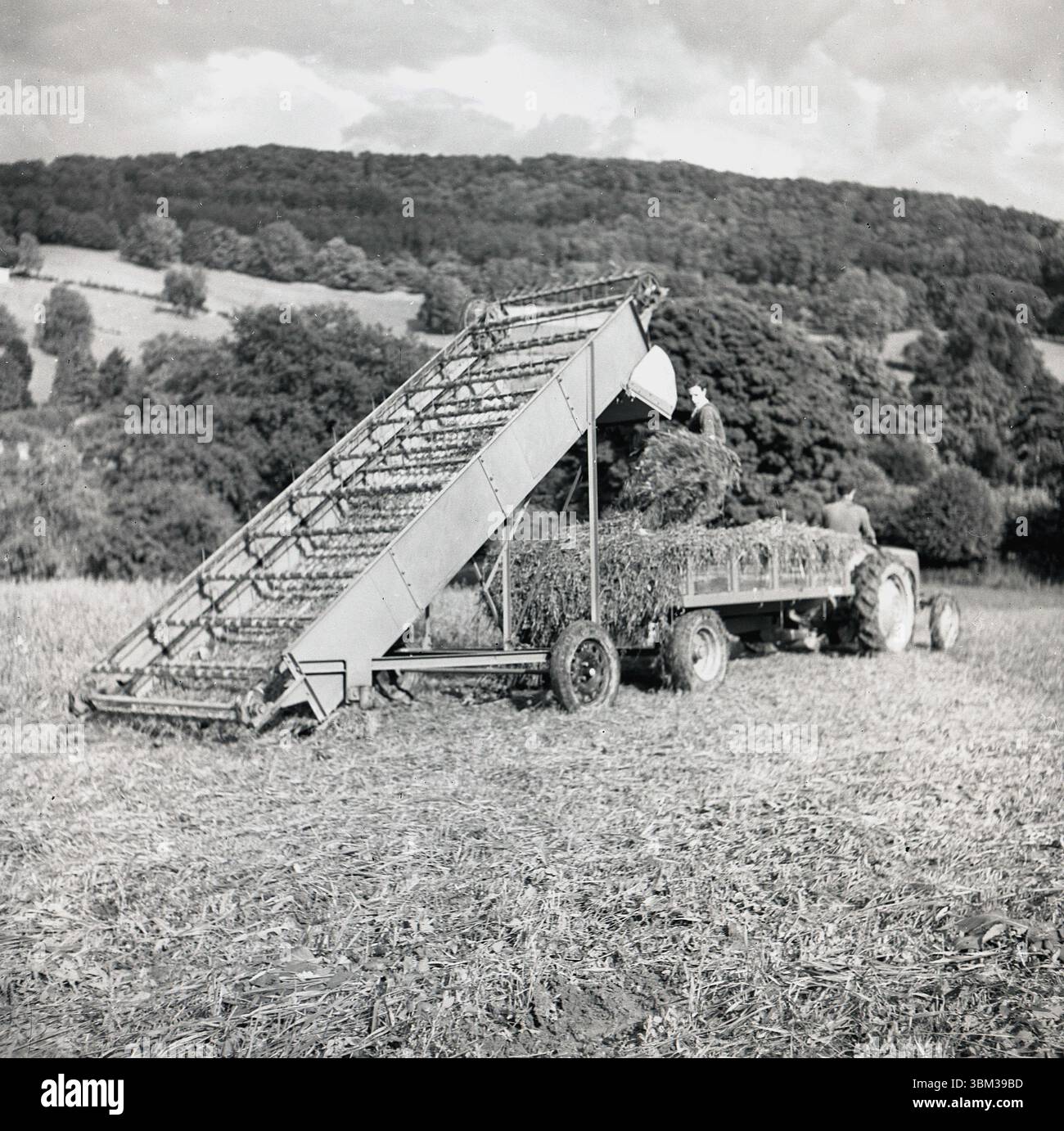 1950s, historical, farming, a farmer on a tractor pulling a trailer and ...