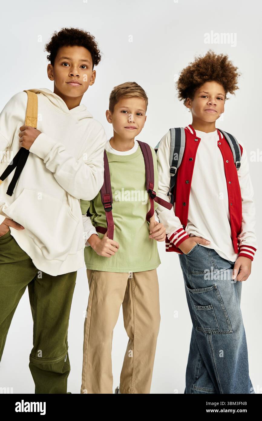 Three adorable boys in trendy outfits stand confidently, sharing a ...