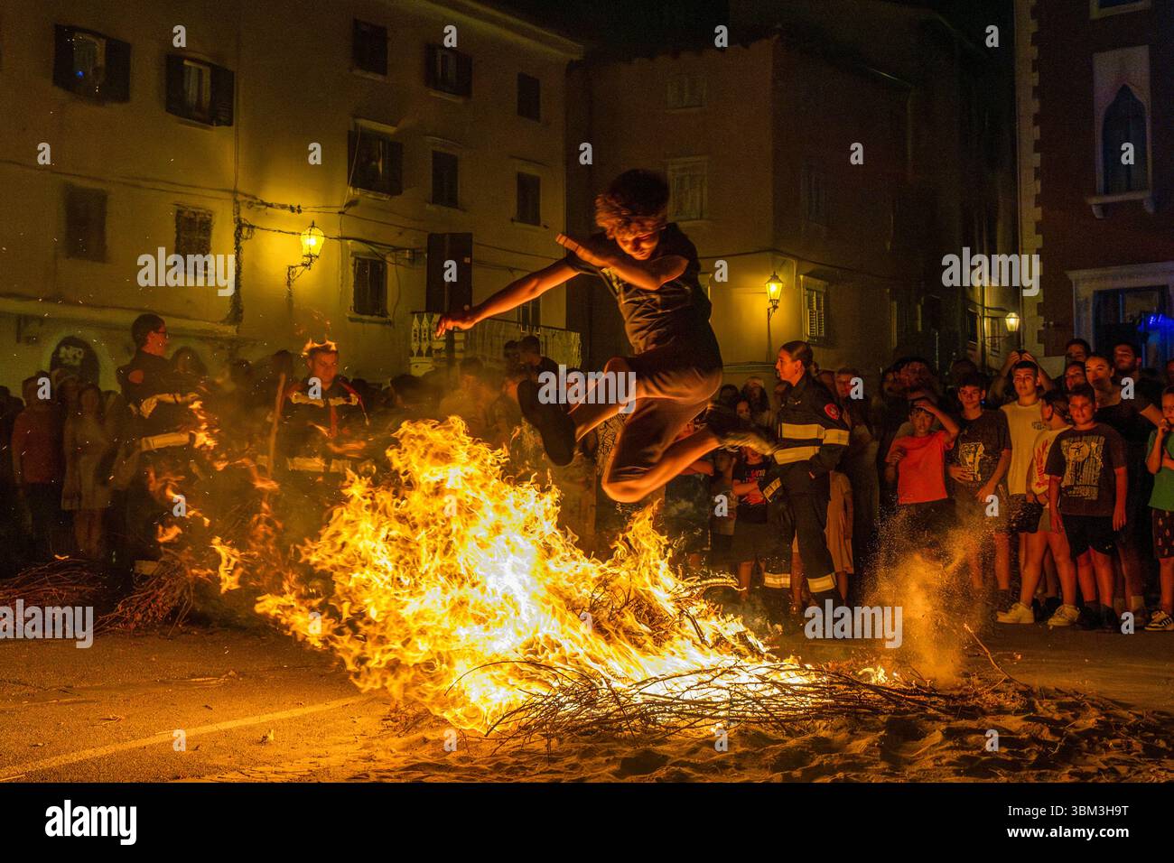 Vodnjan, Hrvatska. 23rd June, 2025. People jump over fire during St ...