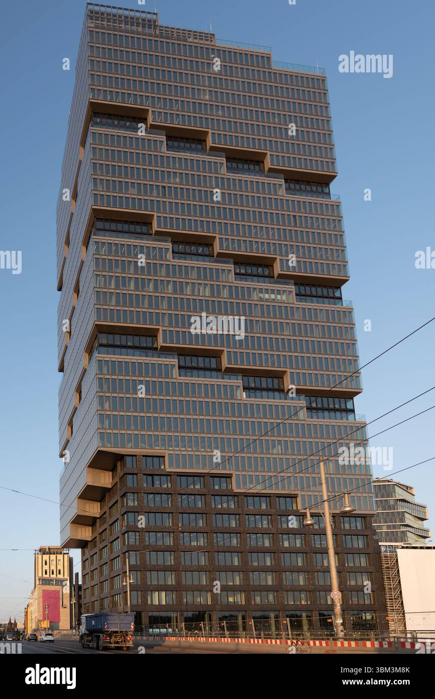 A modern office high-rise with a structured glass facade at sunrise ...