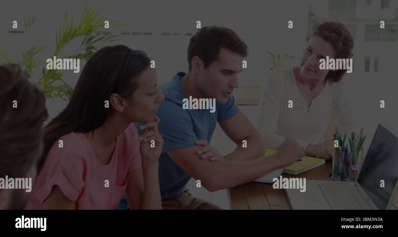 Brainstorming four colleagues using laptop and yellow notepad in ...