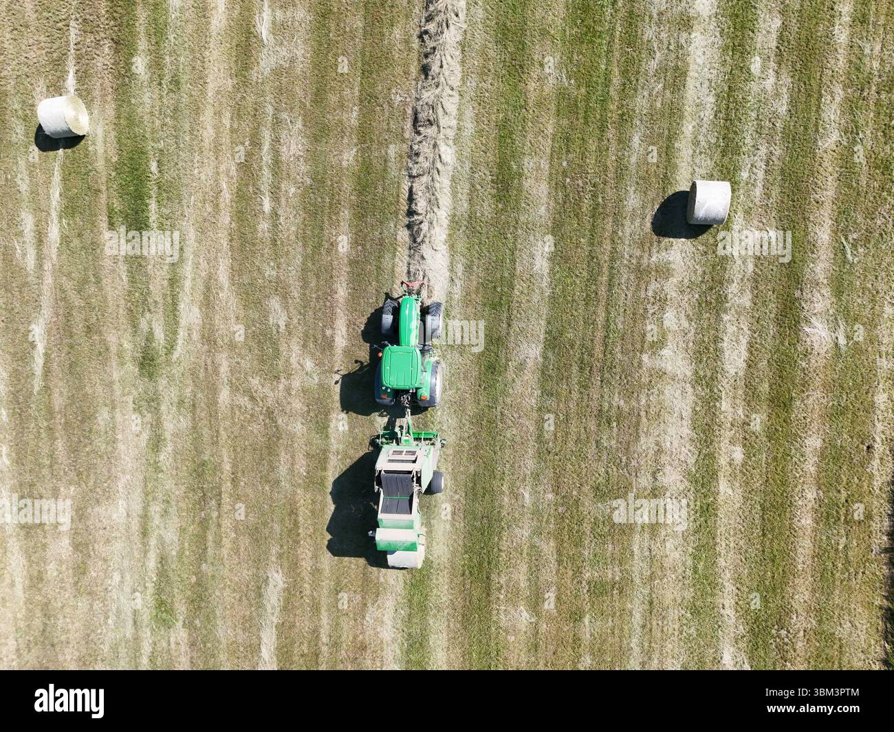 A tractor with a baler in the field, shot with a drone Stock Photo - Alamy