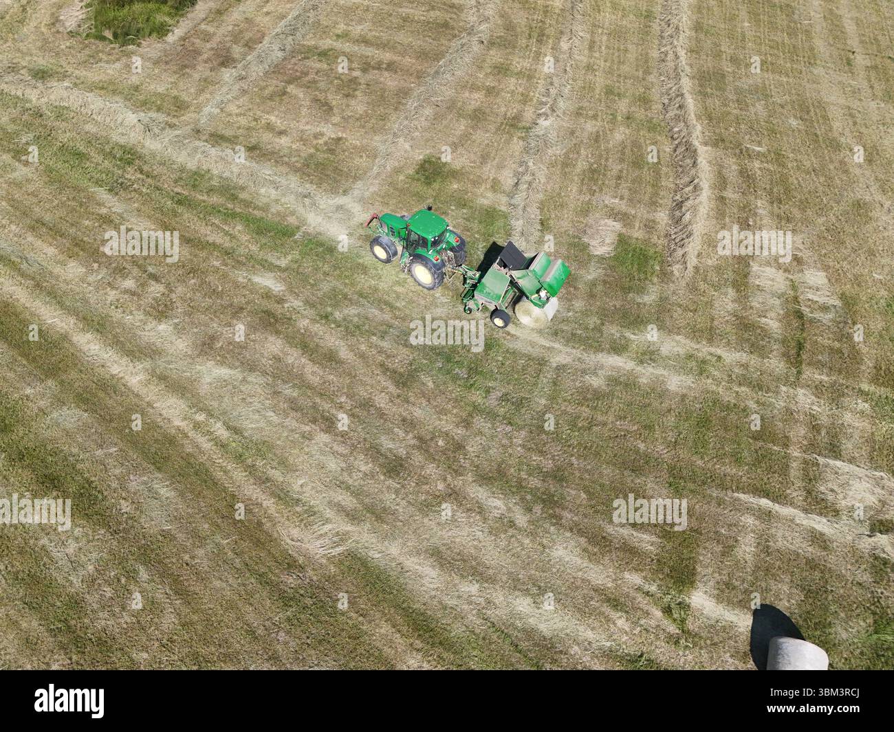 A tractor with a baler in the field, shot with a drone Stock Photo - Alamy