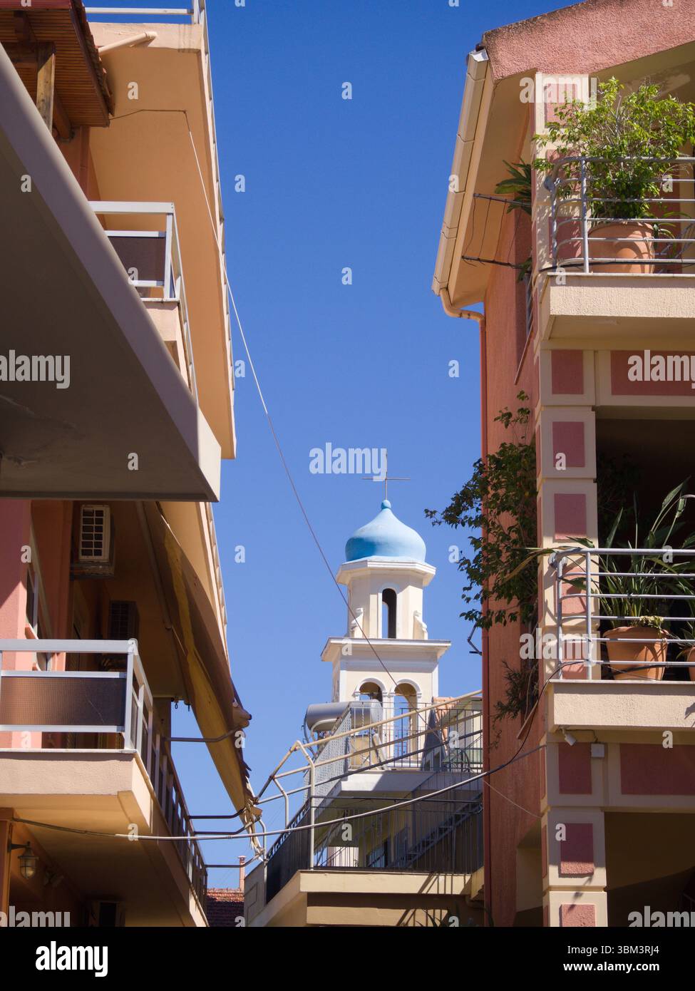 Yellow church tower with blue dome framed by pastel buildings and ...