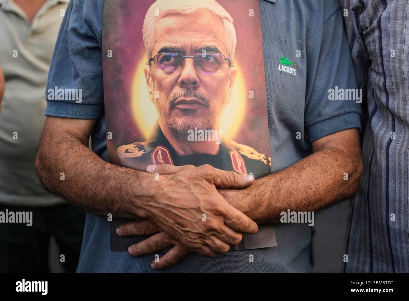 An Iranian man holds a poster of Gen. Mohammad Hossein Bagheri, chief ...