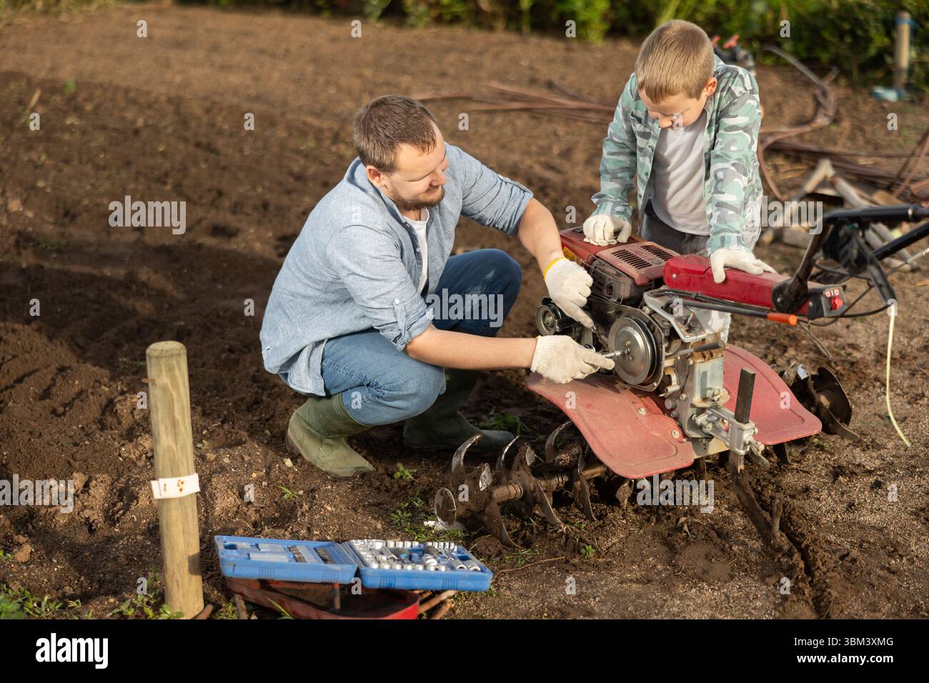 Man and his son are repairing garden equipment Stock Photo - Alamy