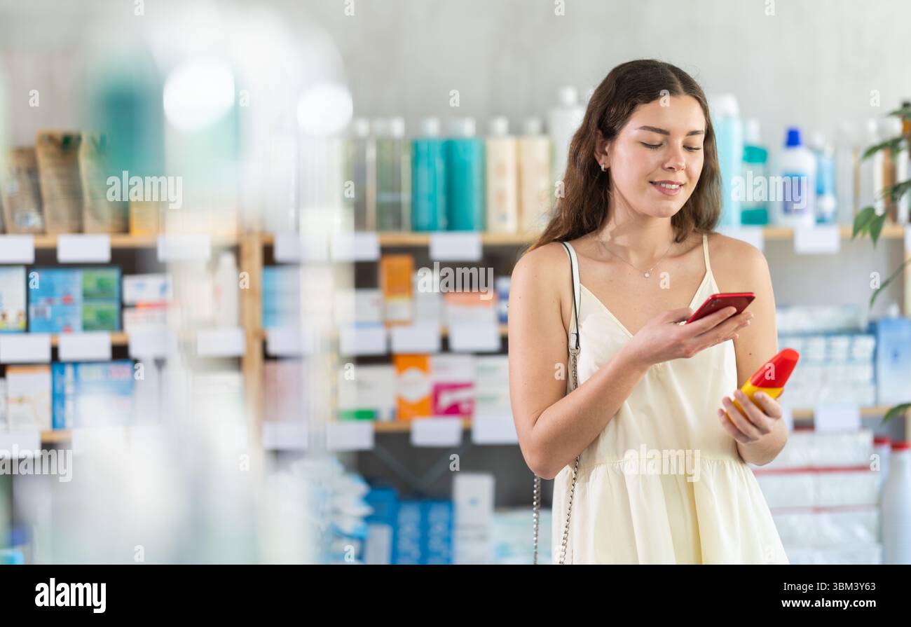 Woman scans on mobile sunscreen in pharmacy Stock Photo - Alamy