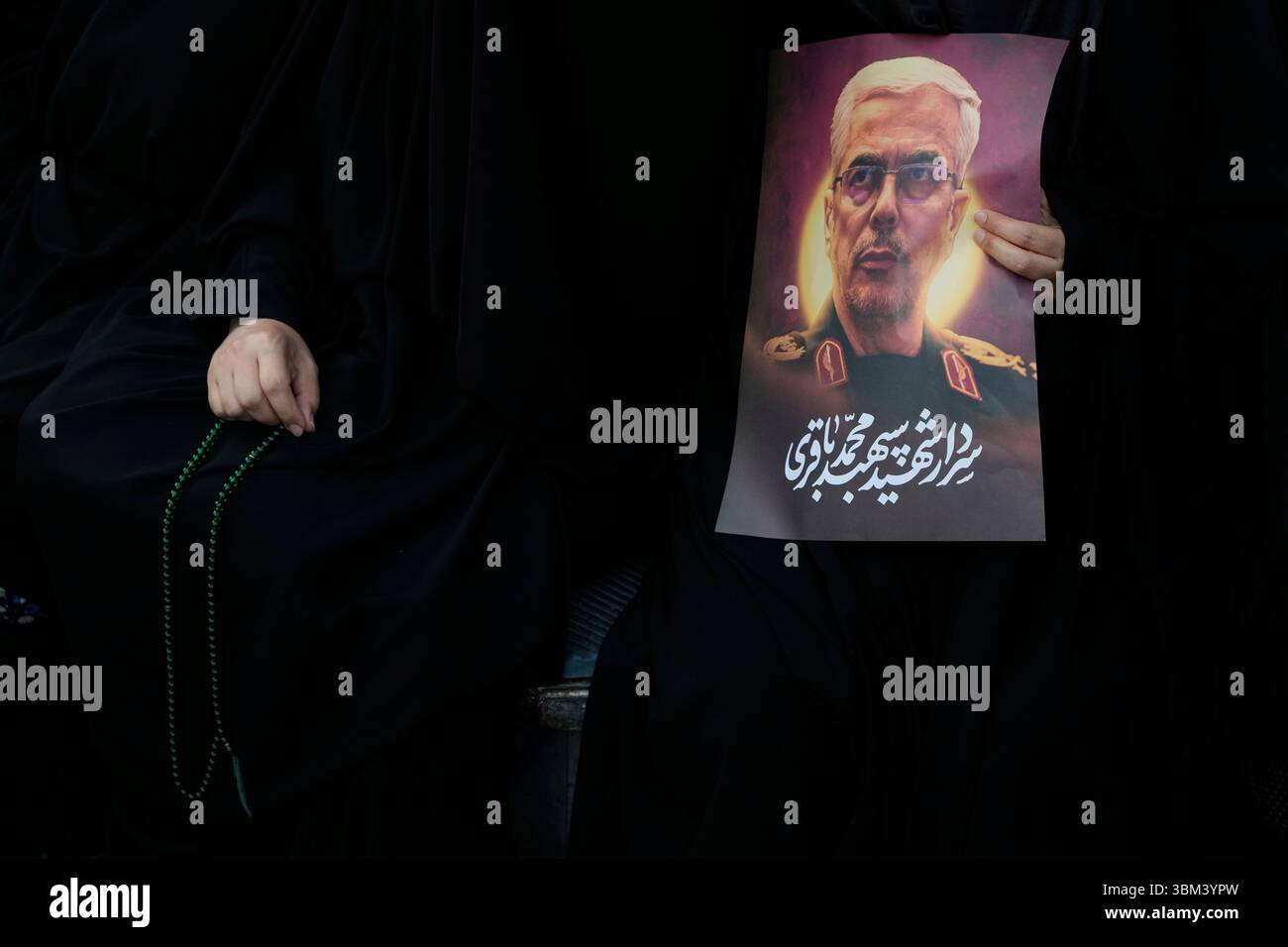 An Iranian woman holds a poster of Gen. Mohammad Hossein Bagheri, chief ...