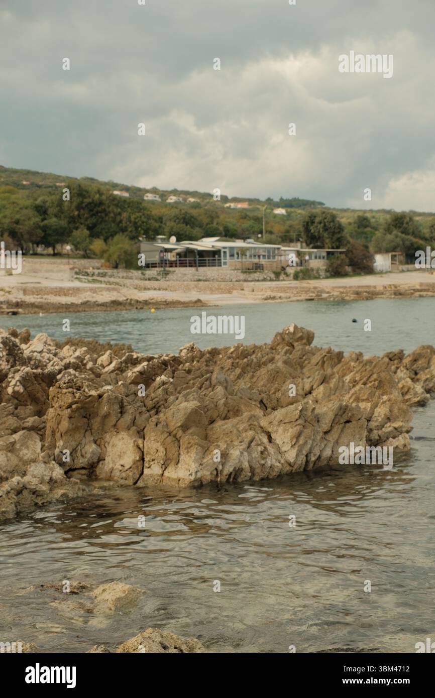 Coastal limestone formations lead the eye toward a small Adriatic town ...