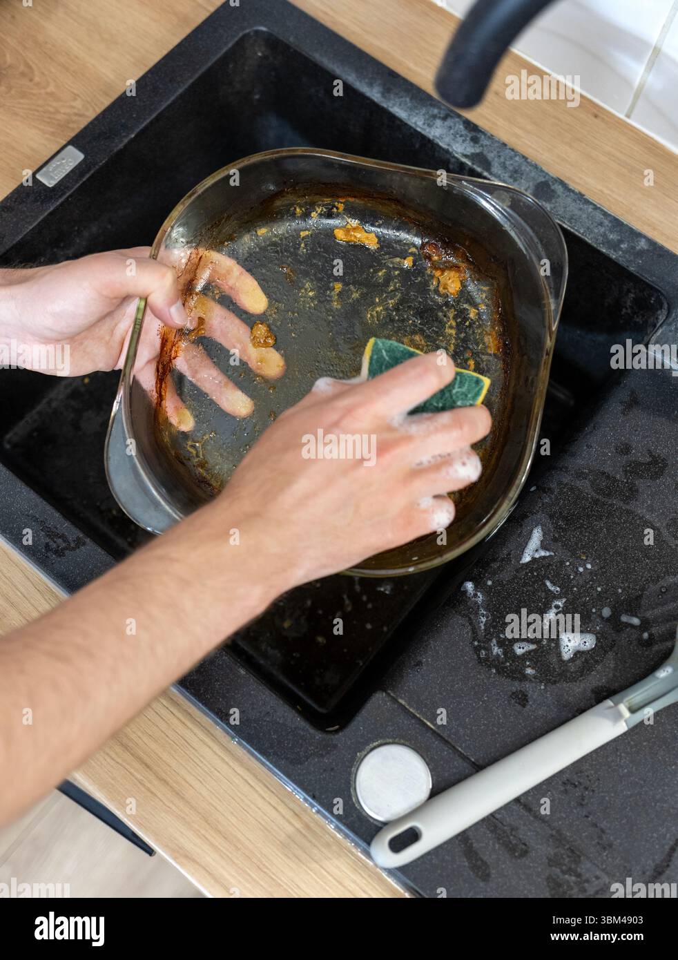close up girl washing glass baking dish by hand. washing greasy dirty ...