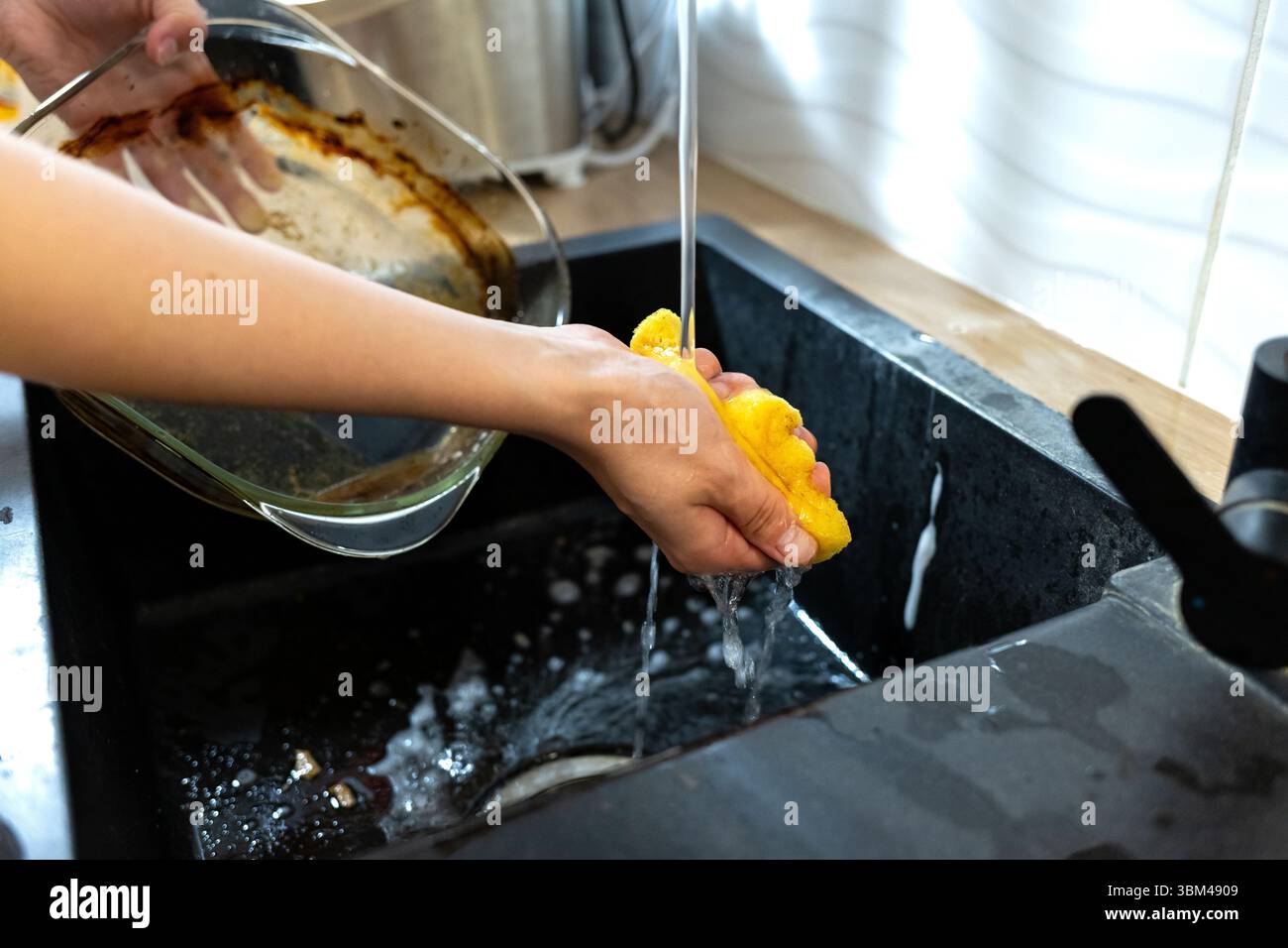 close up girl washing glass baking dish by hand. washing greasy dirty ...