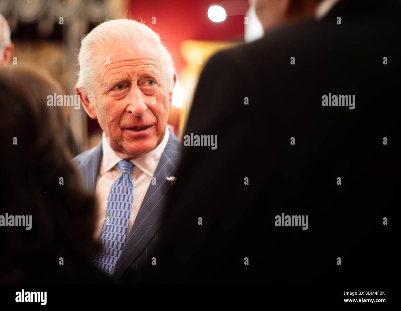 King Charles III speaks with guests during a reception at St James's ...
